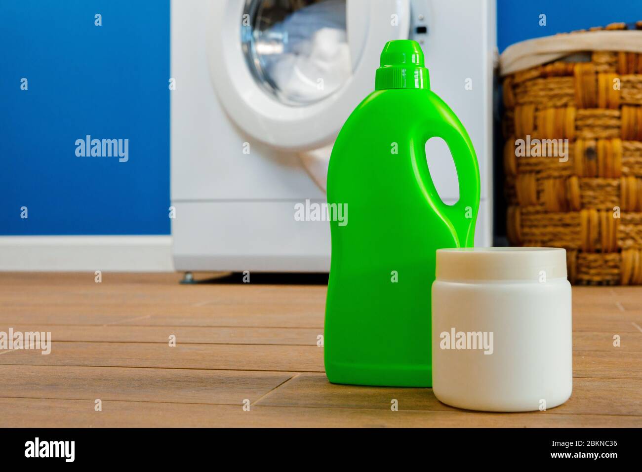 Washing machine with laundry on blue wall background Stock Photo - Alamy