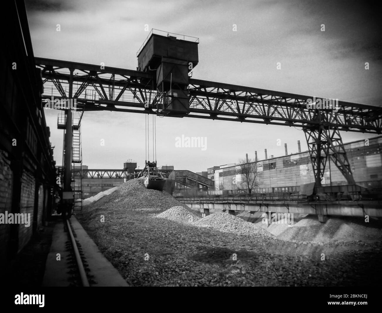 The process of loading crushed stone with a gantry crane. A rusty grab ...
