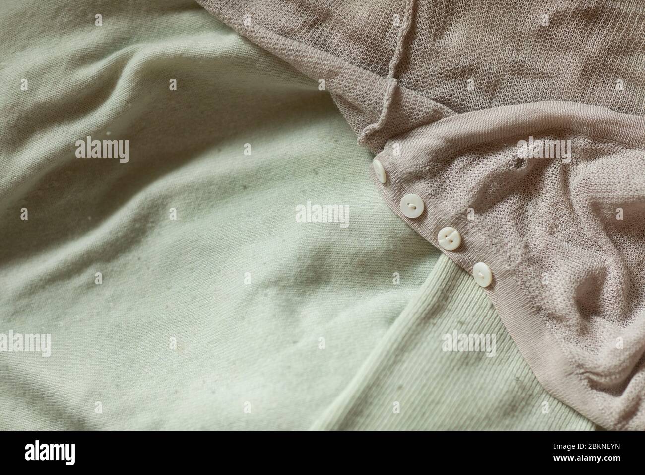 Old clothes in washed out pink and mintgreen colors laying on a pile ...