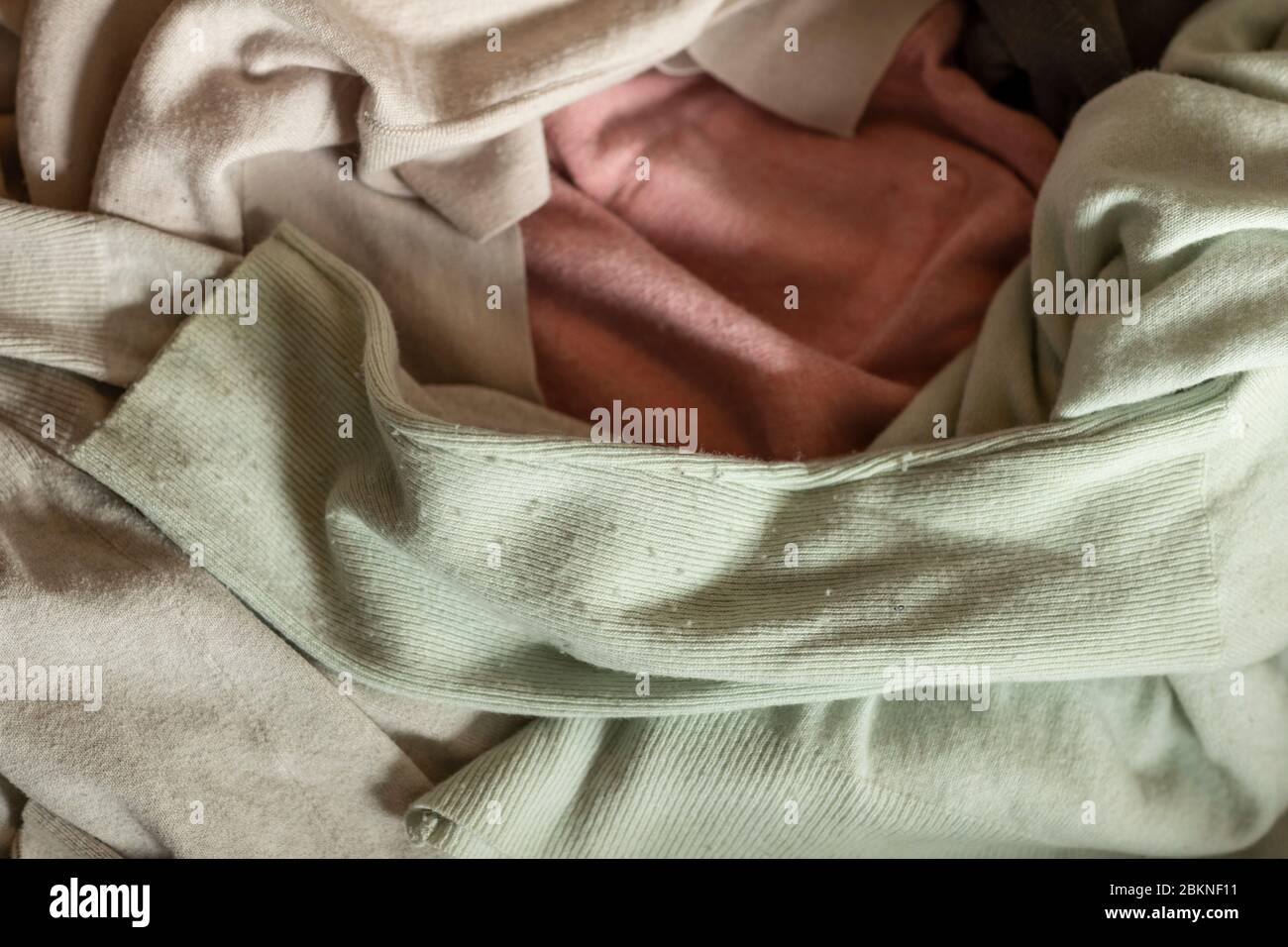 Old clothes in washed out pink and mintgreen colors laying on a pile ...