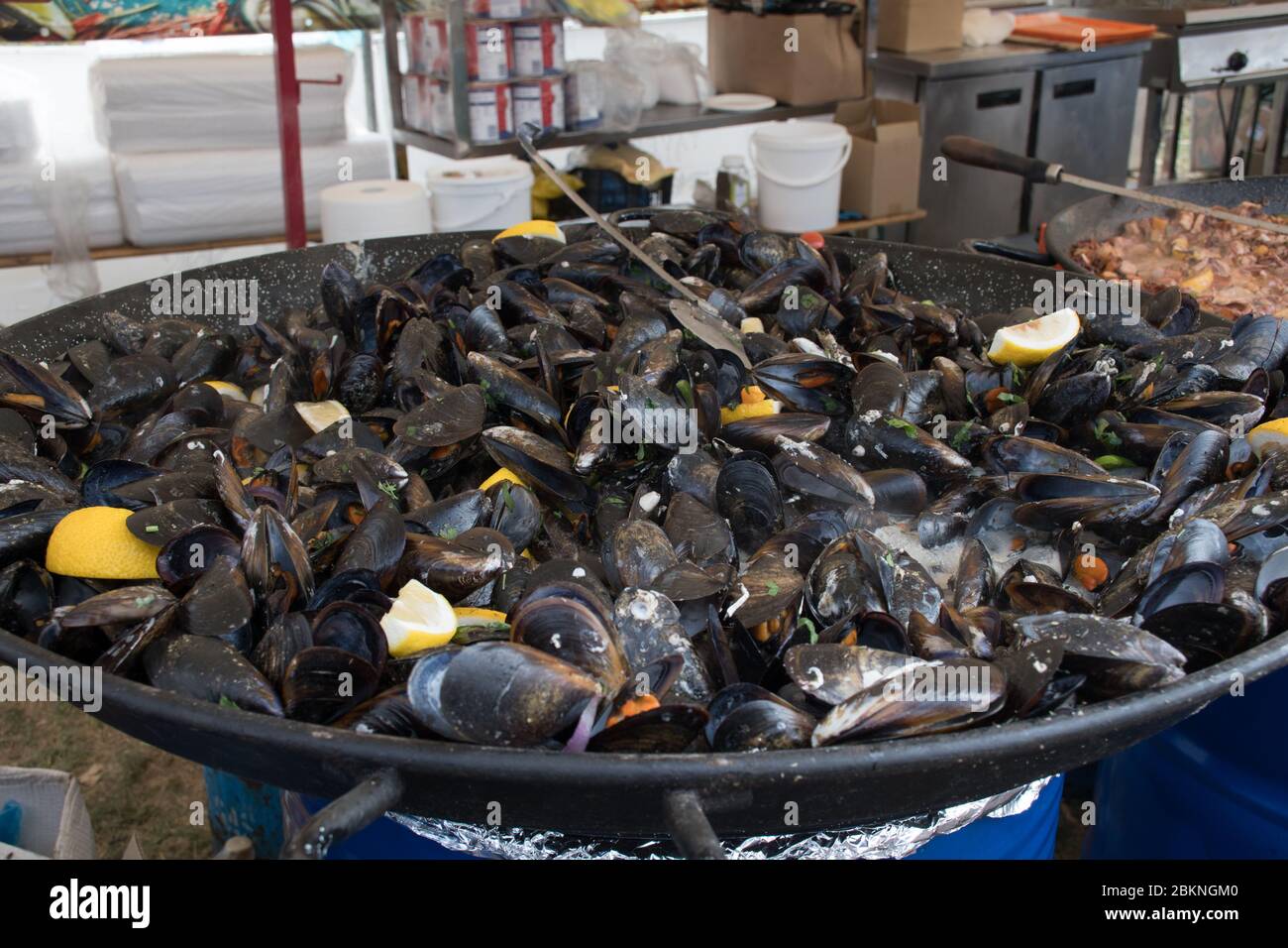 Fresh mussels in shells at steam pan. Seafood barbecue outdoors ...