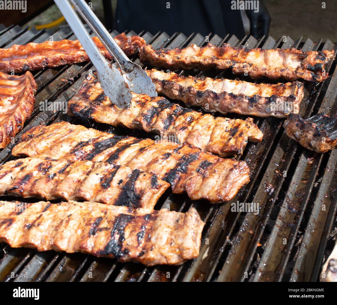 Chef cooking fresh pork ribs on the charcoal grill, during food ...