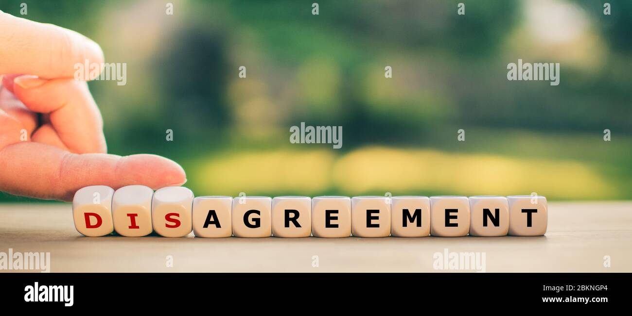 Hand turns dice and changes the expression "disagreement" to "agreement ...