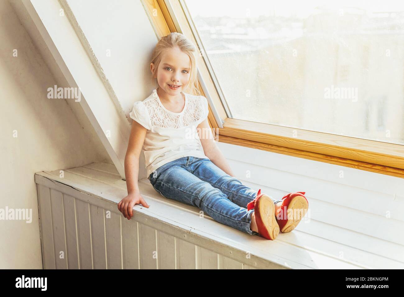 Stay Home Stay Safe. Little cute sweet smiling girl in jeans and white ...