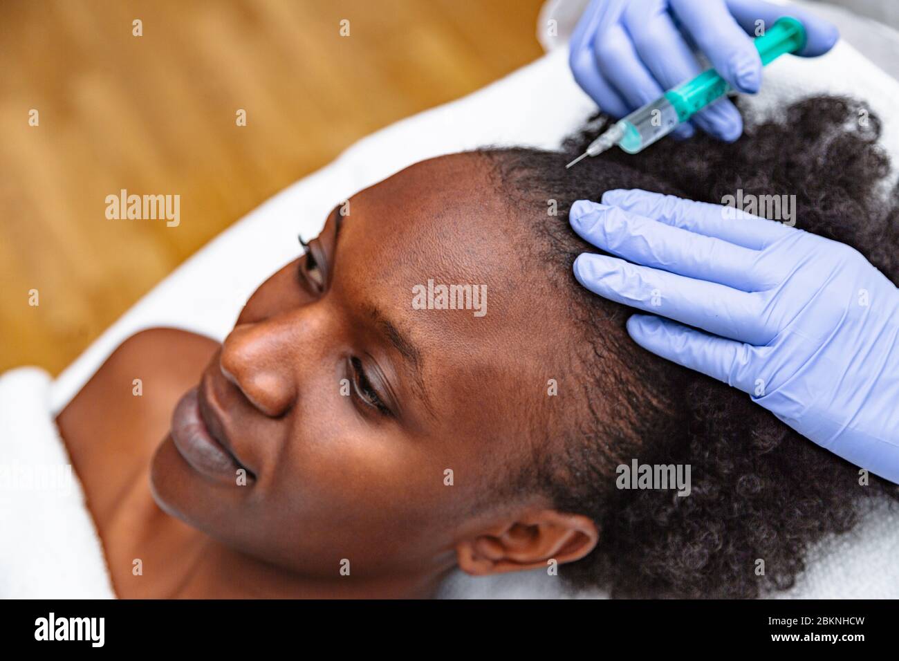 Doctor makes head beauty injection to female patient Stock Photo - Alamy
