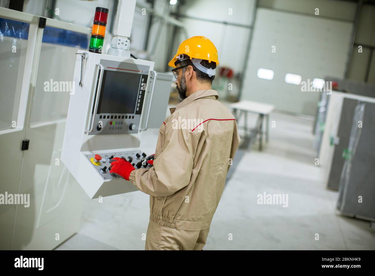 Portrait of mature man operating machine units in modern wood factory ...