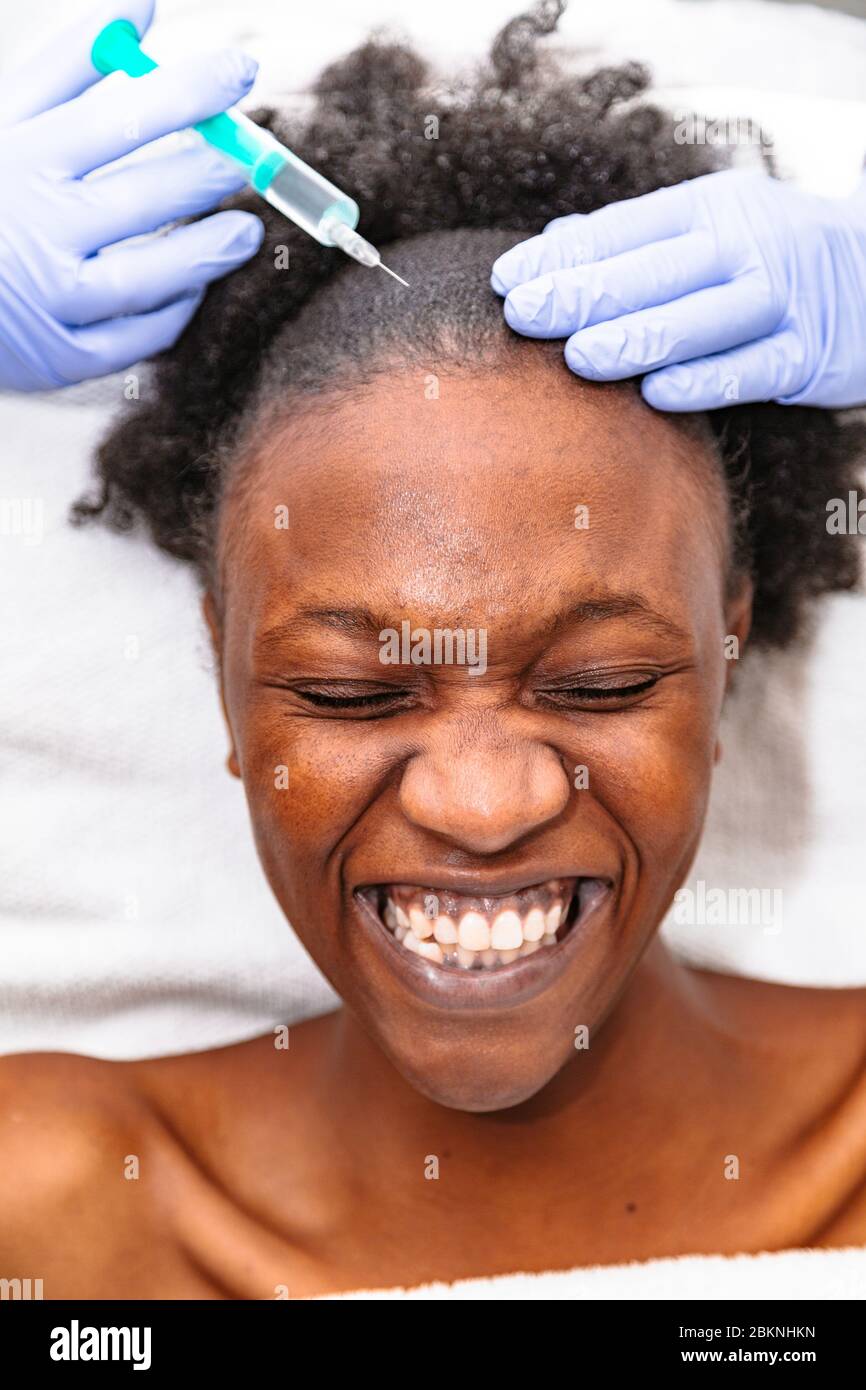 Doctor makes head beauty injection to male patient Stock Photo - Alamy