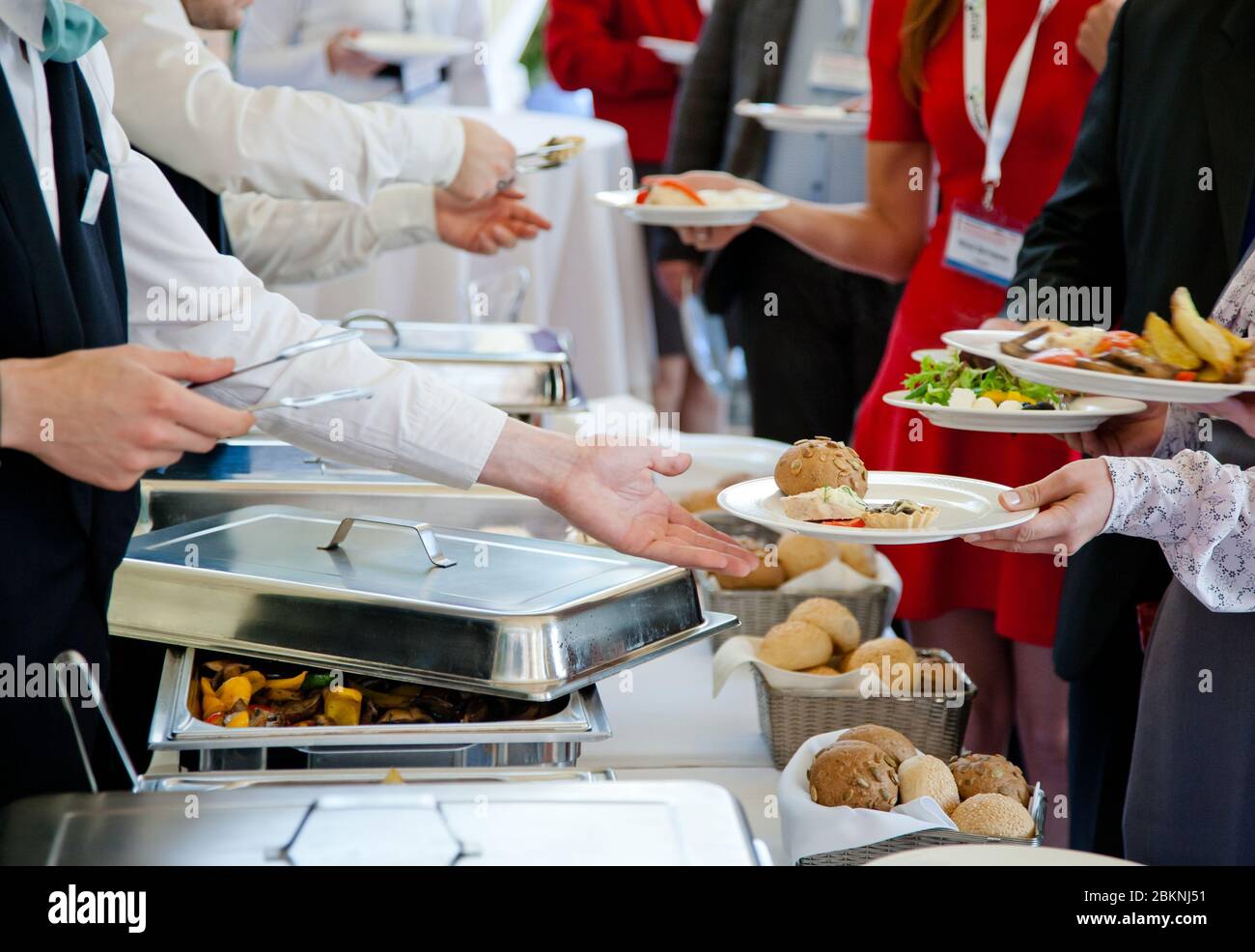 People at the reception taking food on plates Stock Photo - Alamy