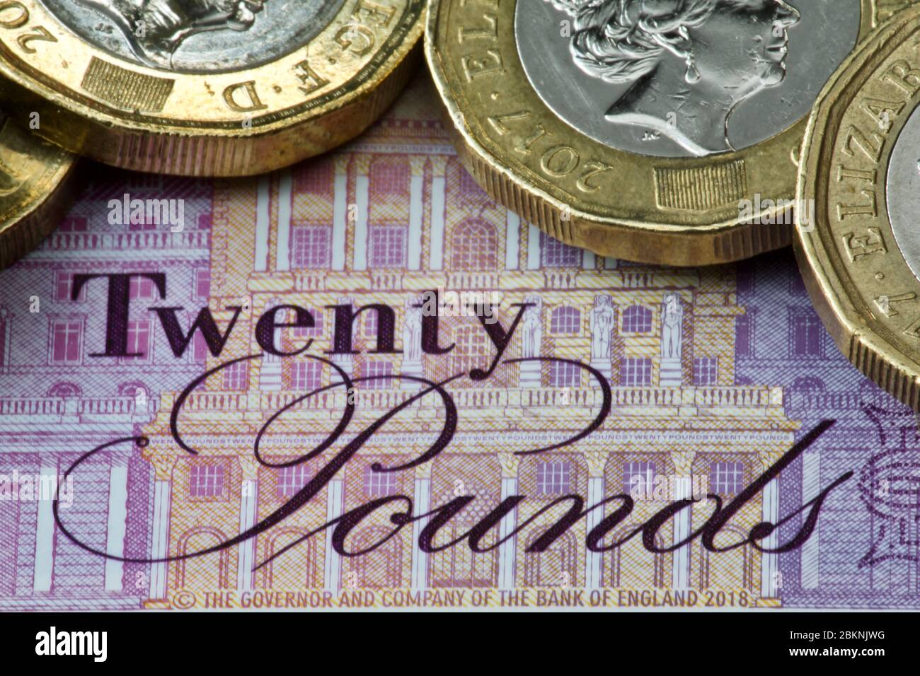 £1 pound coins on a twenty pound banknote Stock Photo - Alamy
