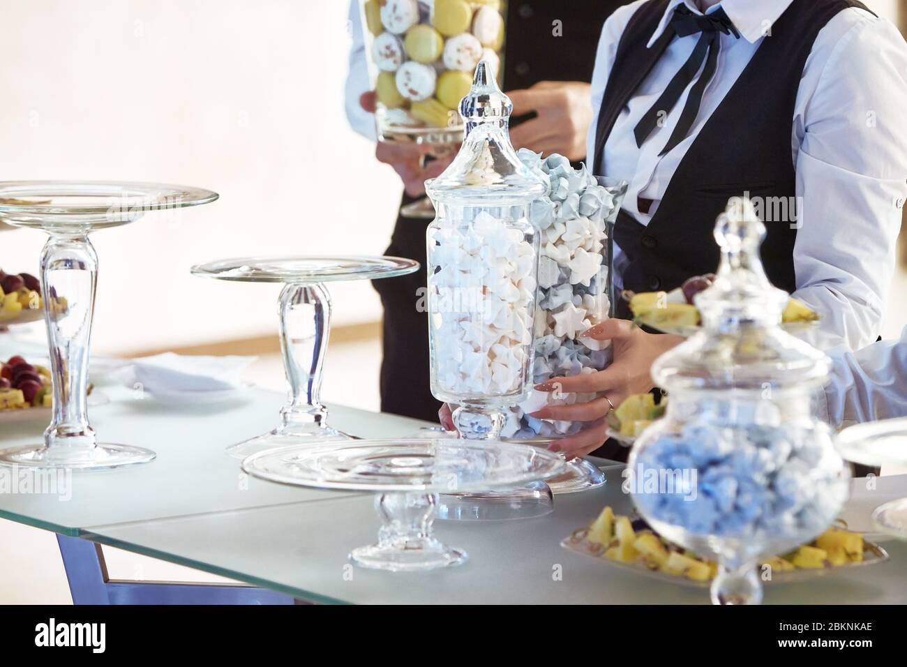 The waiter's hands of men and women, serving sweets in a glass ...