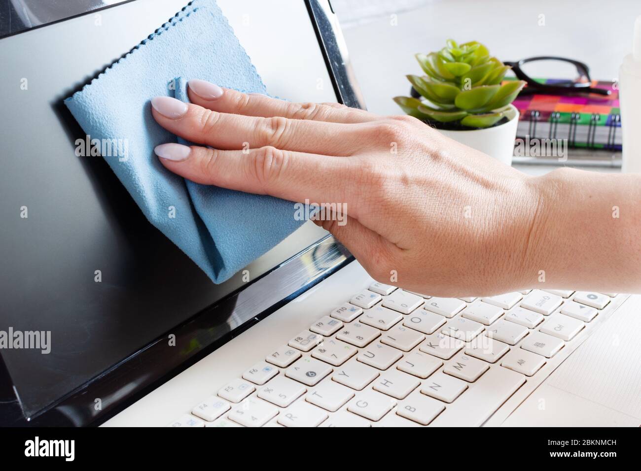 Woman hand disinfecting computer screen with antibacterial cloth ...