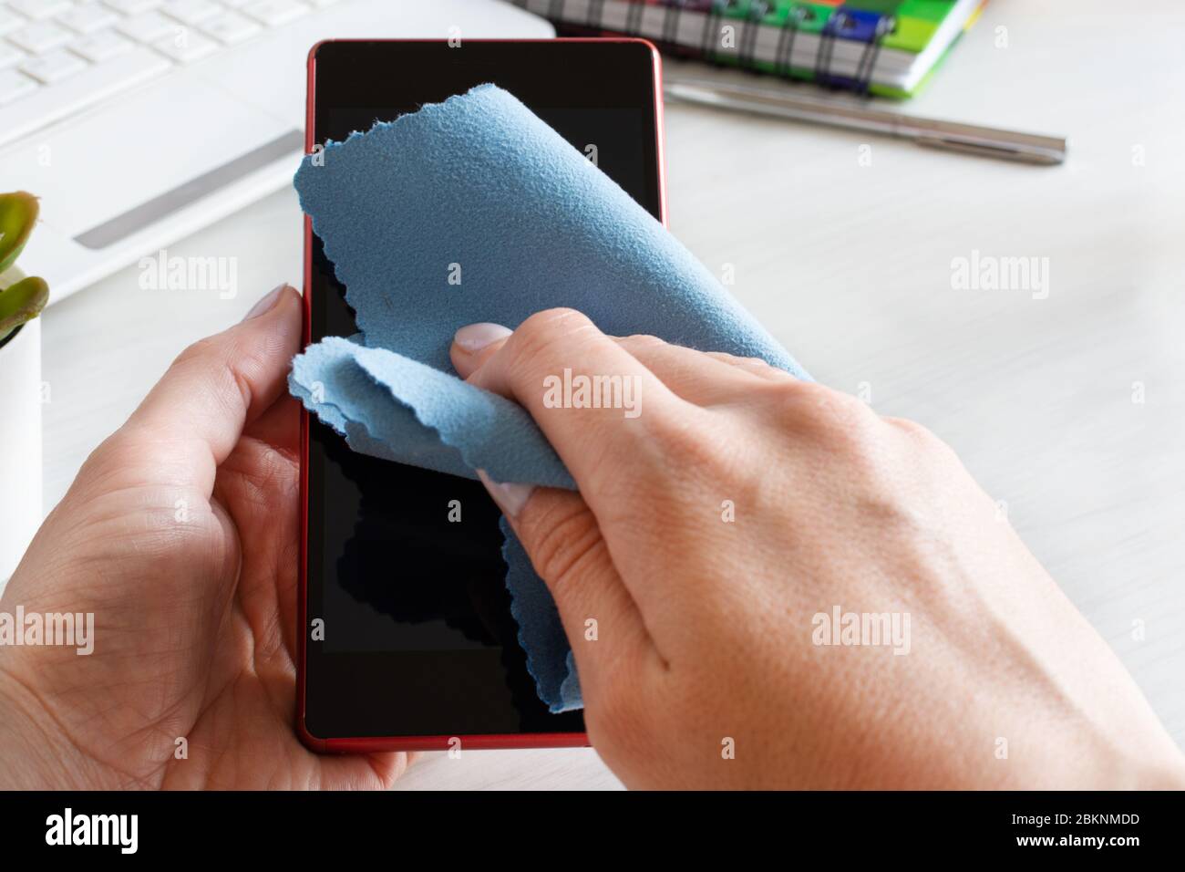 Woman hand disinfecting smartphone screen with antibacterial cloth ...