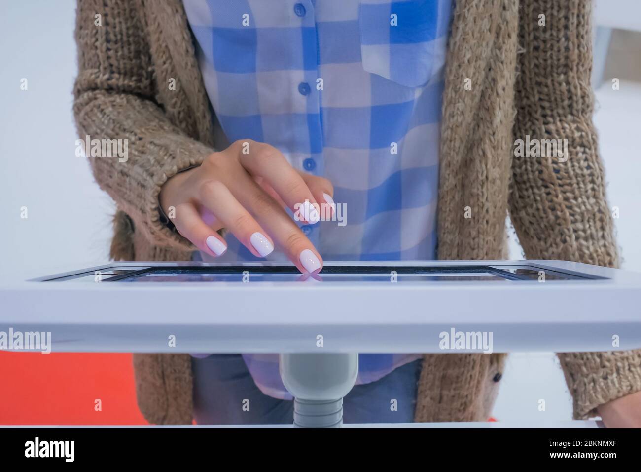 Woman hand using touchscreen display of interactive floor standing ...