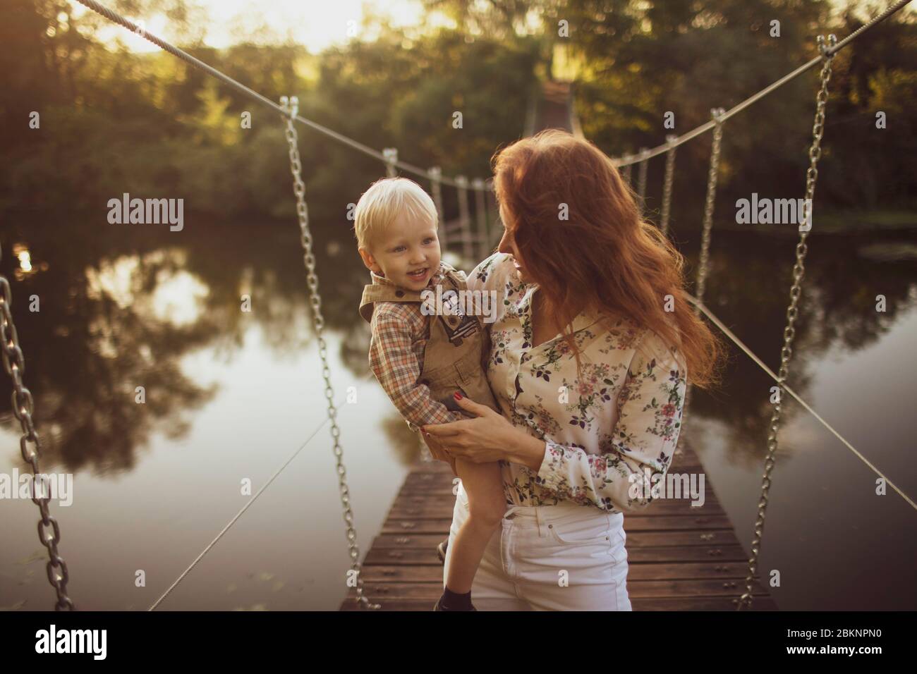 Mother and child walking on a suspension bridge Stock Photo - Alamy