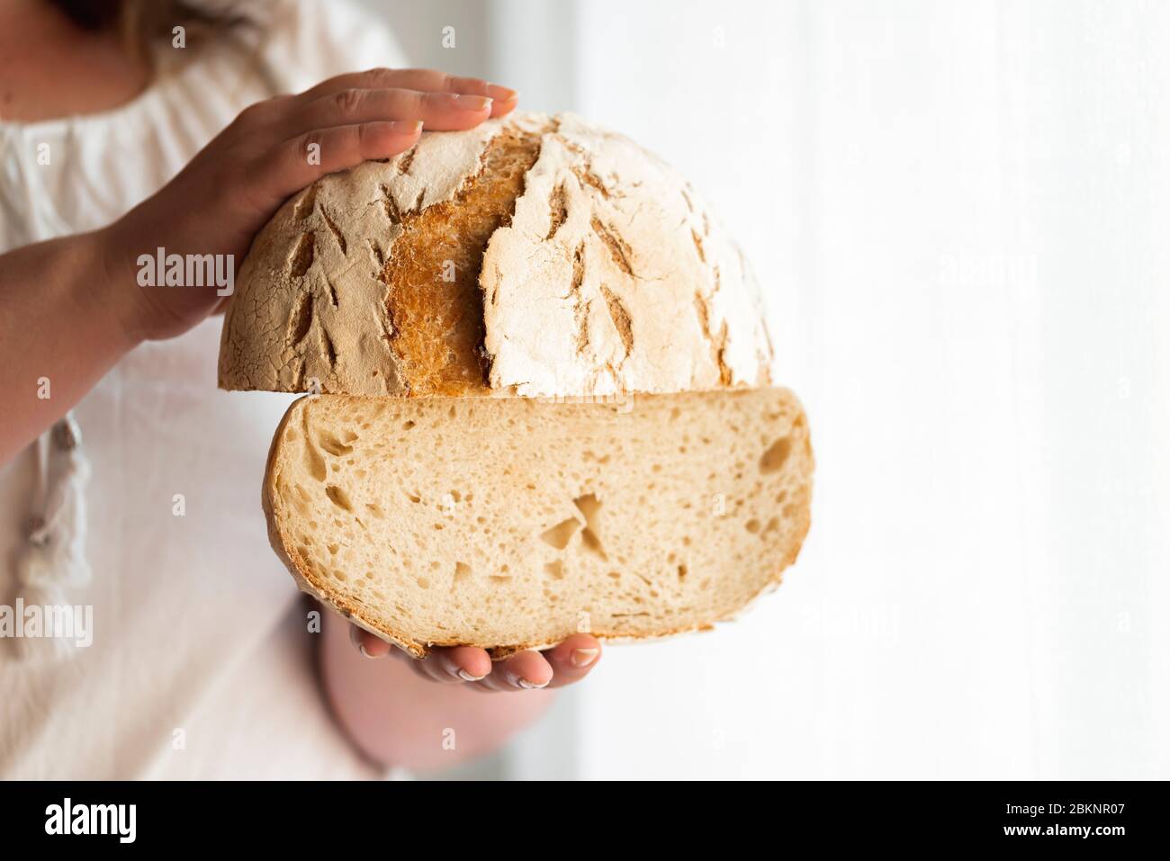 Unrecognizable woman holding sourdough bread, homemade with wheat flour ...