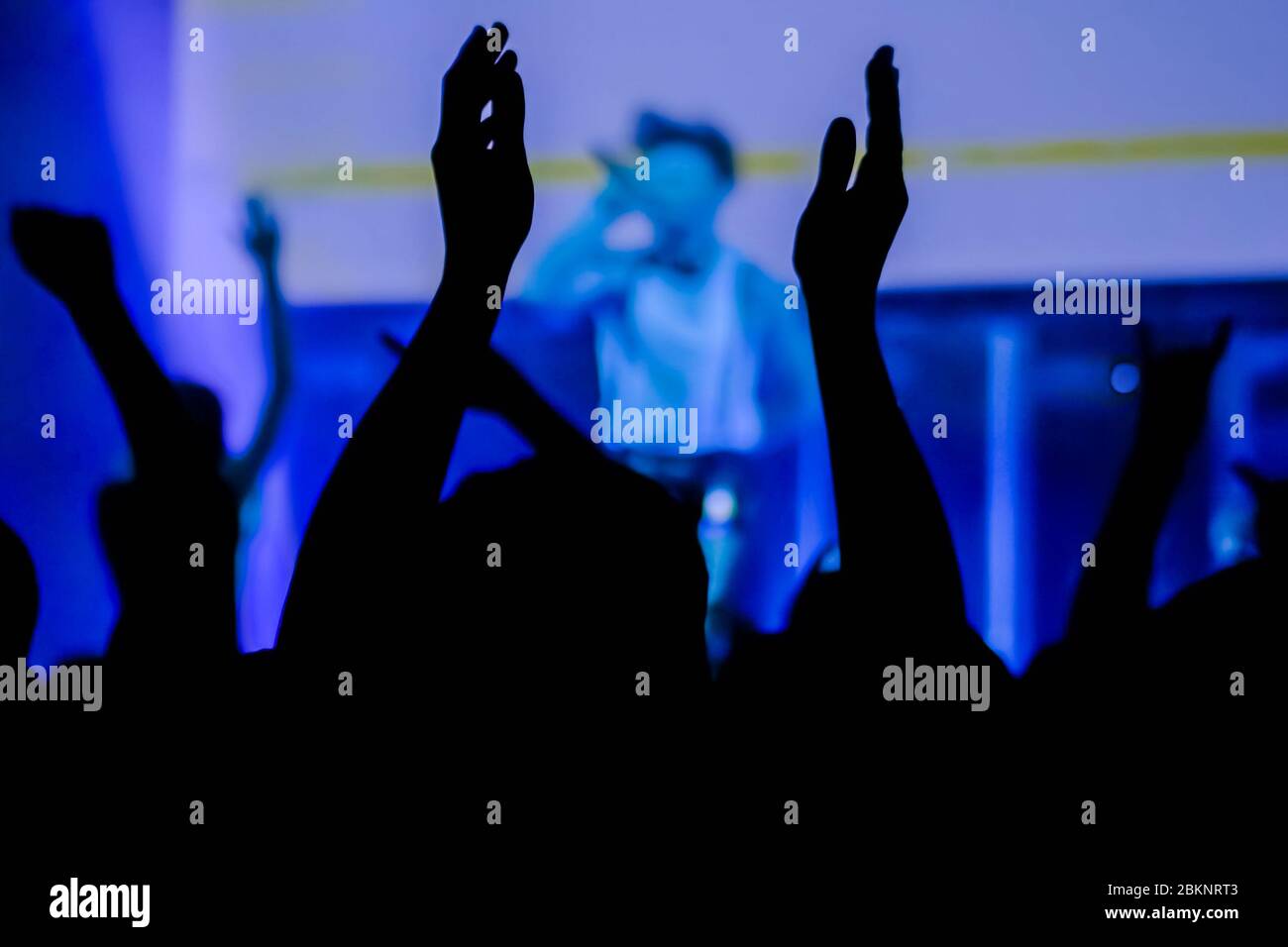 Man silhouette partying, cheering, raising hands up and clapping at ...