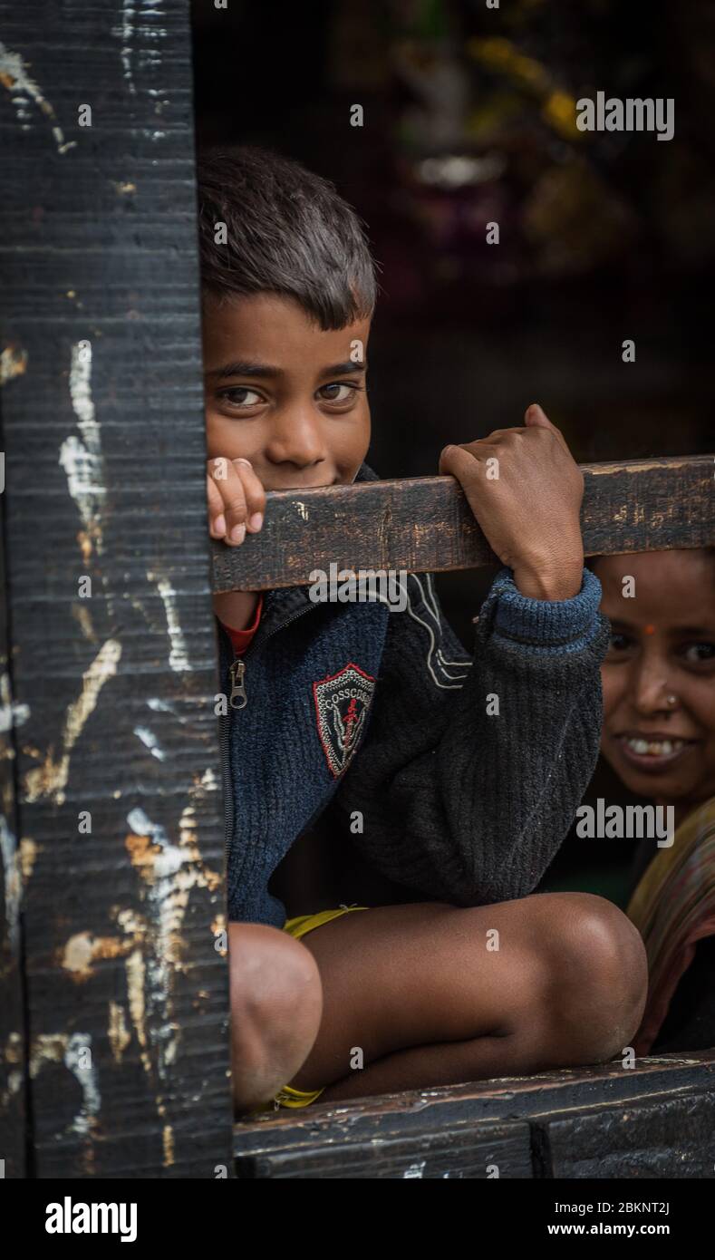 Portrait of a young Indian boy looking out of a window. Assam ...