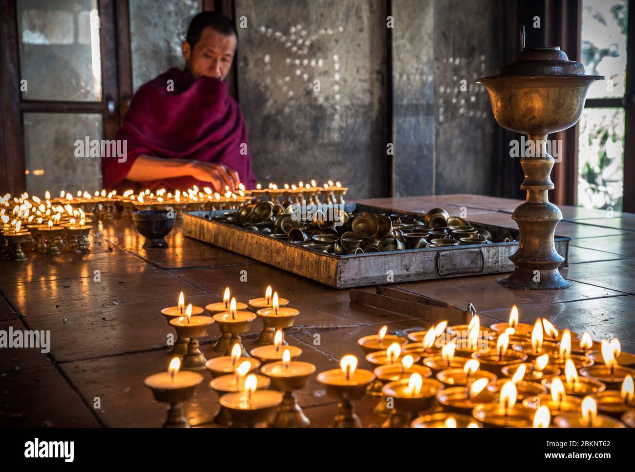 Monk lighting candles at Bomdila Monastery, Arunachal Pradesh, India ...