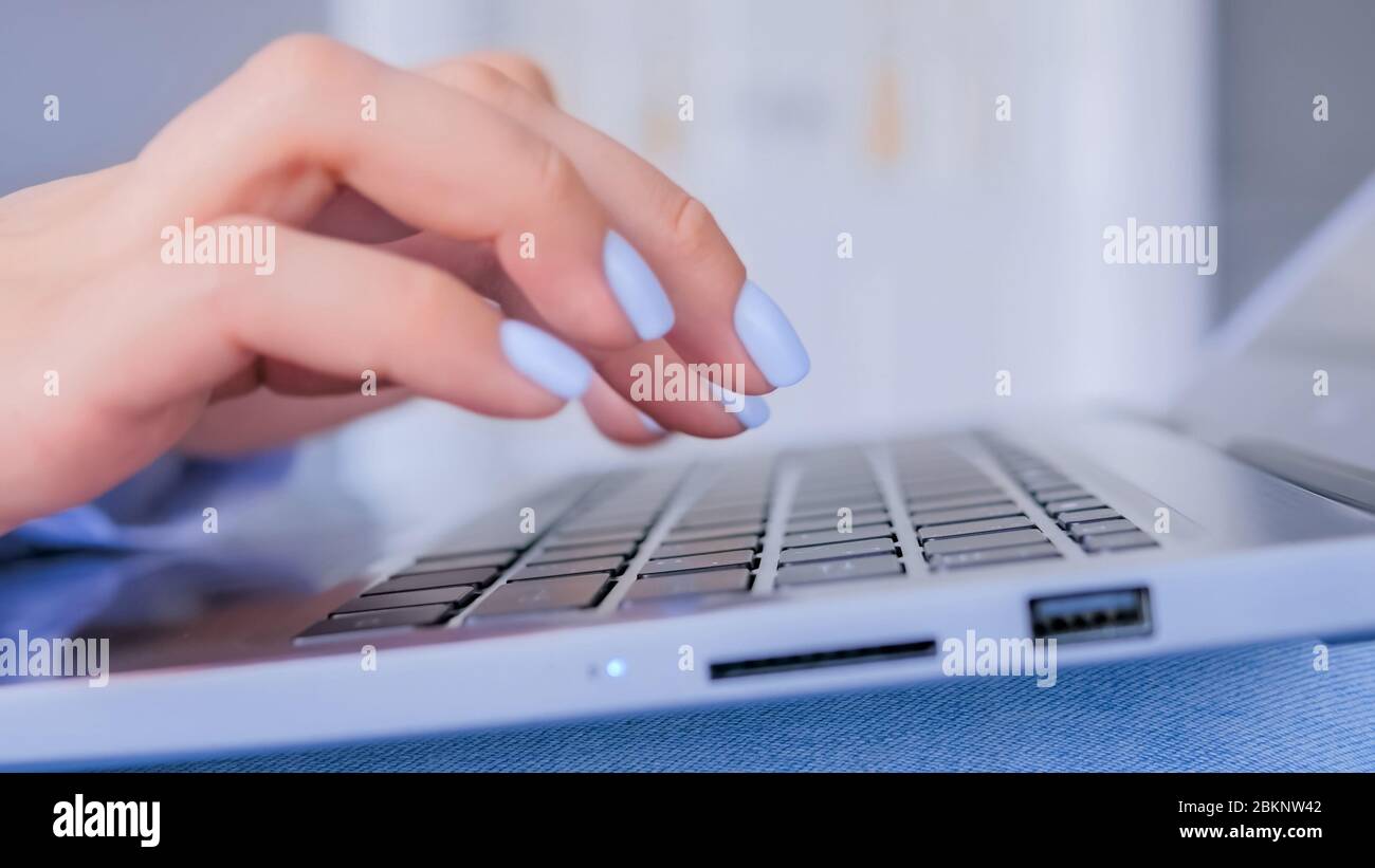 Woman hands with manicure typing on laptop computer keyboard - close up ...