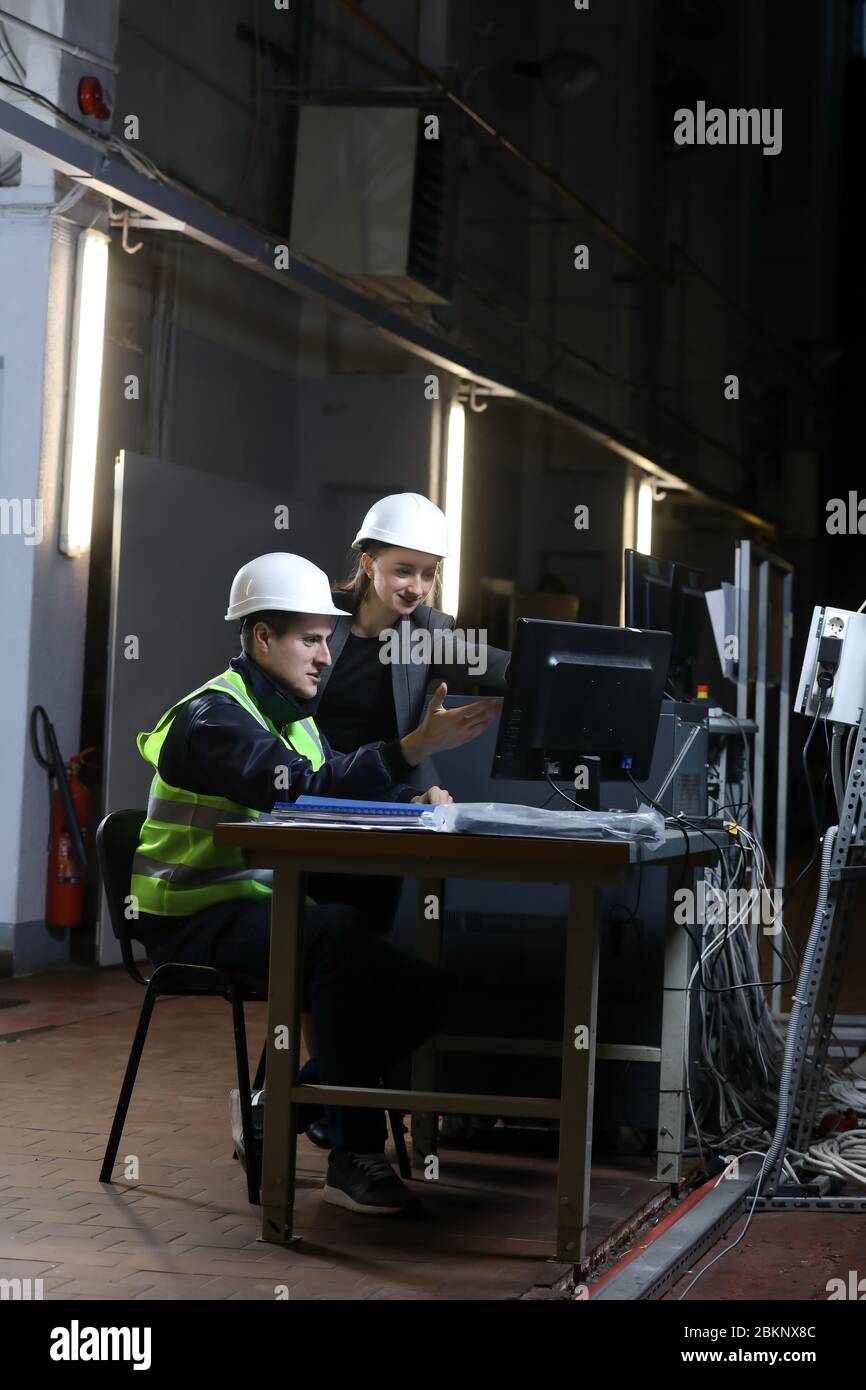 Portrait of a female factory manager in a white hard hat and business ...