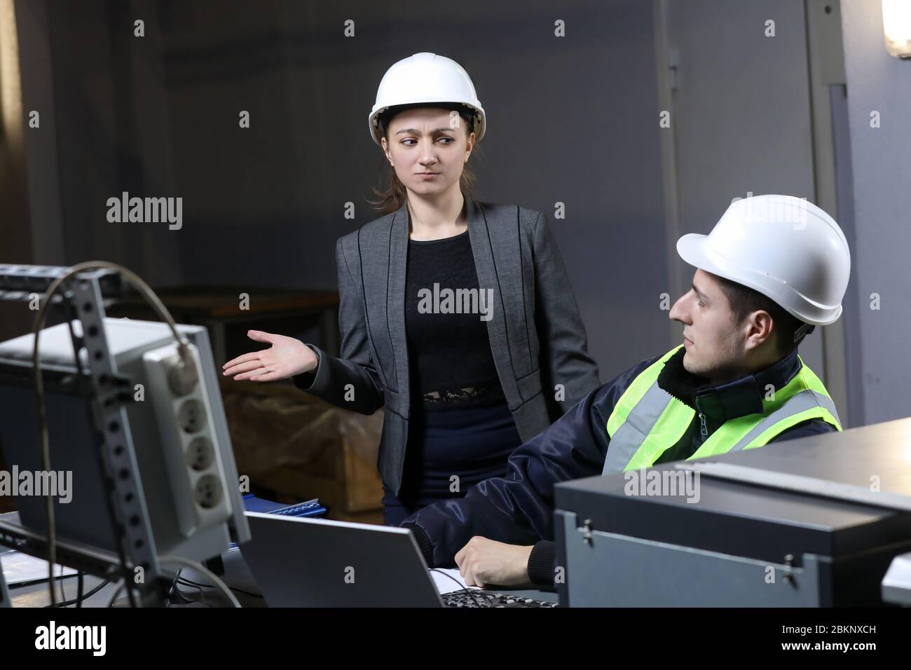 Portrait of a female factory manager in a white hard hat and business ...