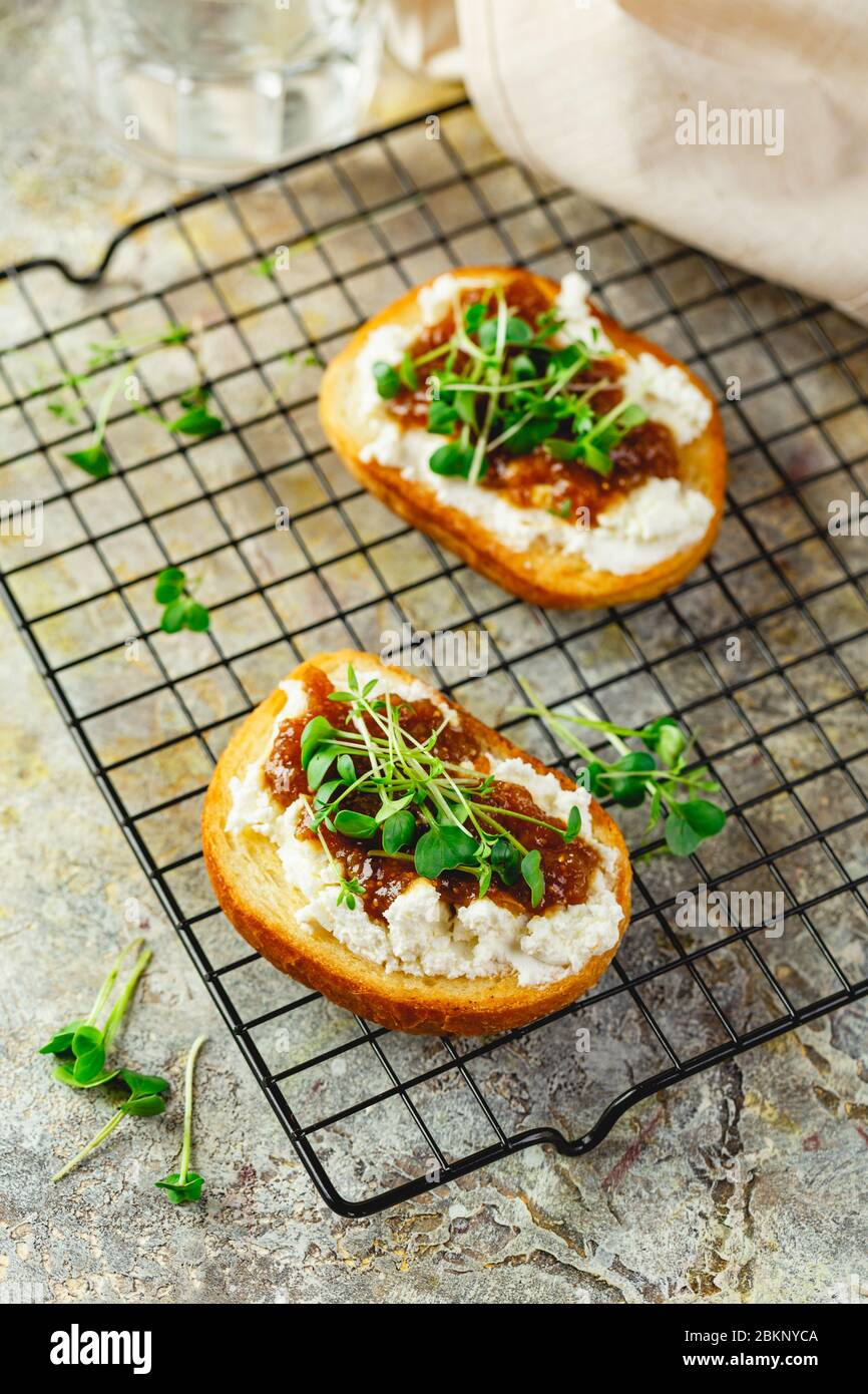 Canape or crostini with toasted baguette, cottage cheese, fig jam and ...