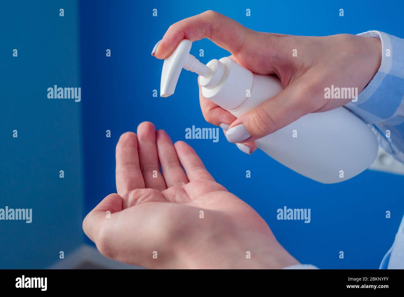 Woman pushing dispenser, squeezing out antiseptic gel on palm, cleaning ...