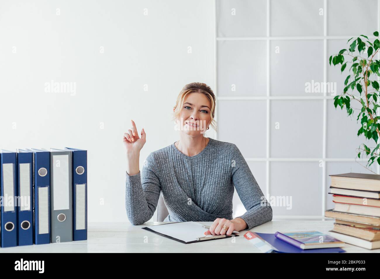 portrait of a beautiful business woman at a table with books at work in ...