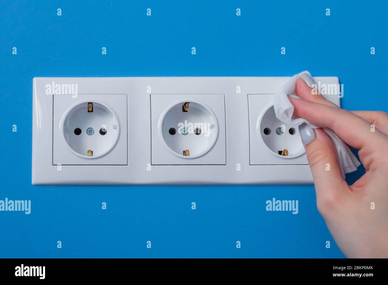 Woman cleaning electrical european outlet, socket with disinfectant wet ...