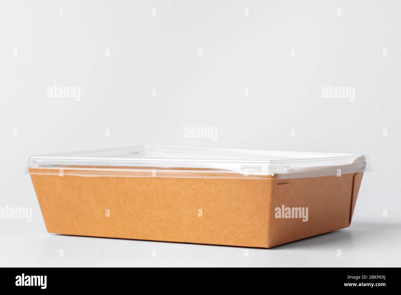 Craft paper disposable box with plastic cover on grey background, copy ...