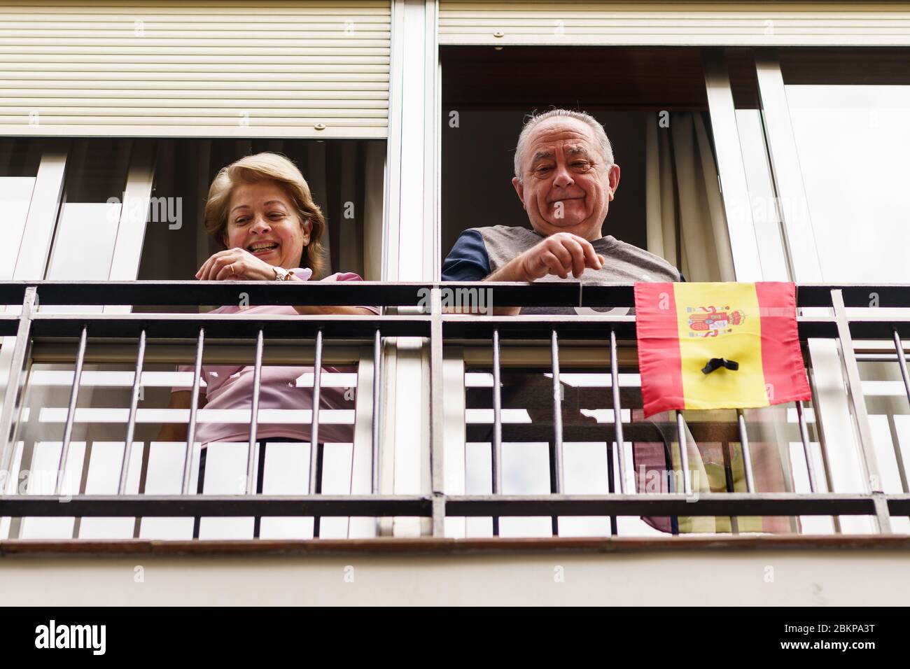 Older couple clapping in the window in support of people against the ...