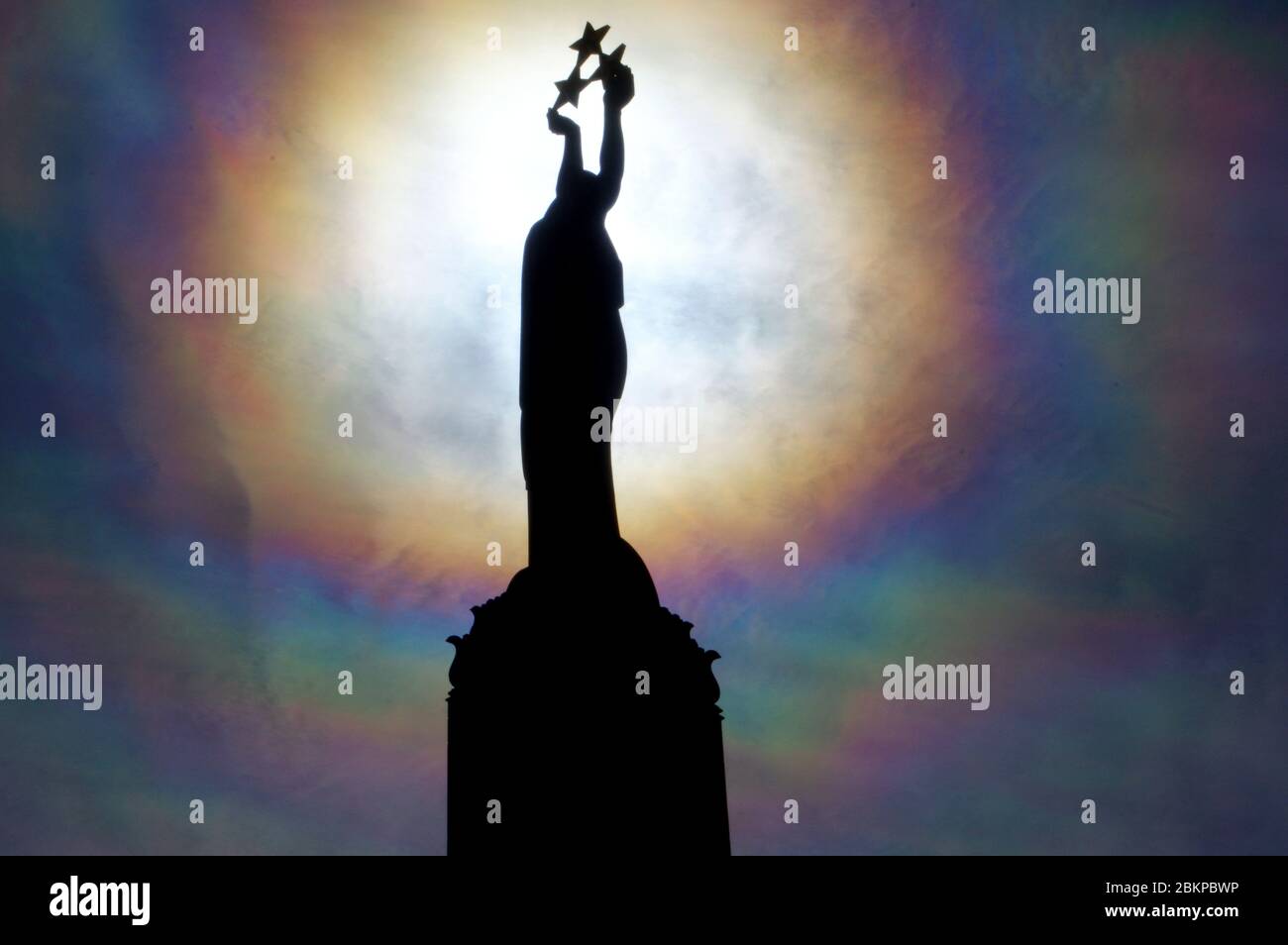Monument of freedom in Riga. Woman holding three gold stars which ...