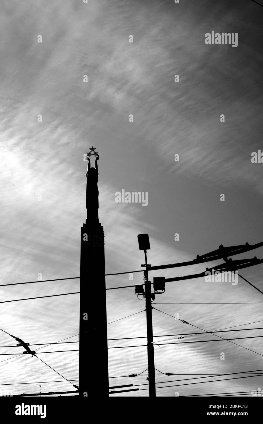 Monument of freedom in Riga. Woman holding three gold stars which ...