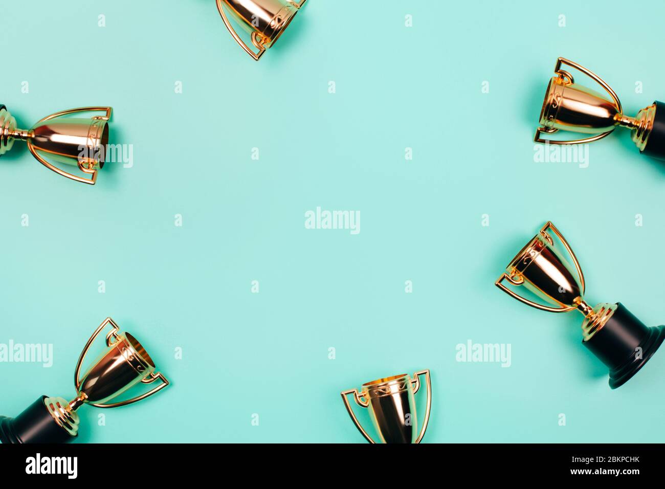 Frame made of winner cups on a pastel blue background with copy space ...