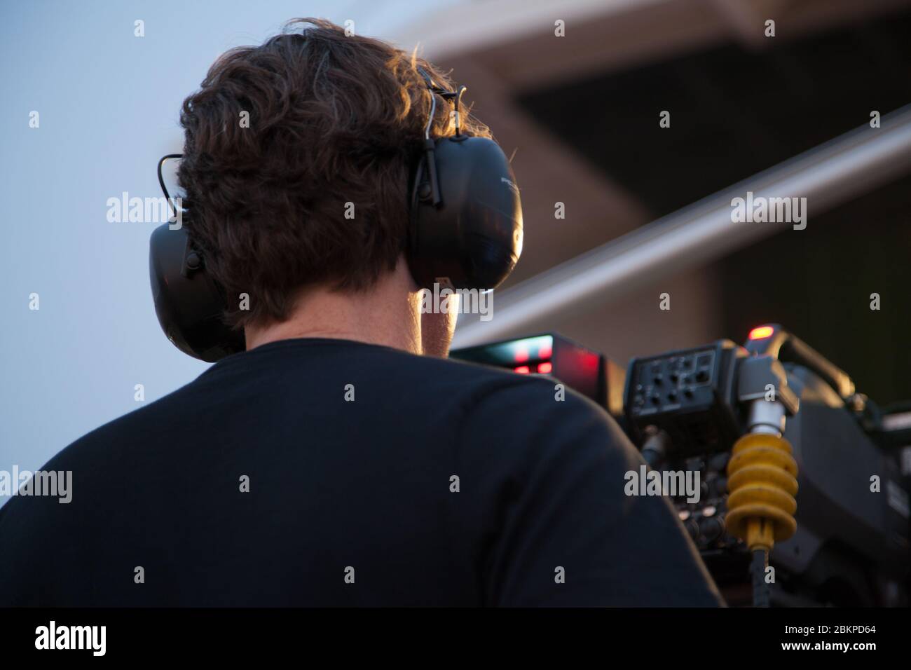 Close up of back view of camera man filming Stock Photo - Alamy