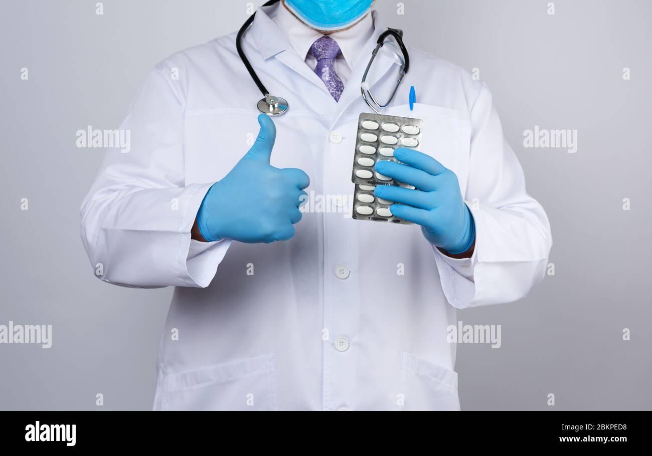 doctor therapist is dressed in a white uniform coat and blue sterile ...