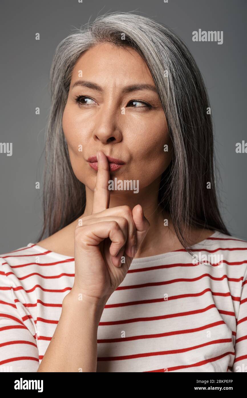 Image Of Adult Mature Woman Wearing Striped Shirt Holding Finger On