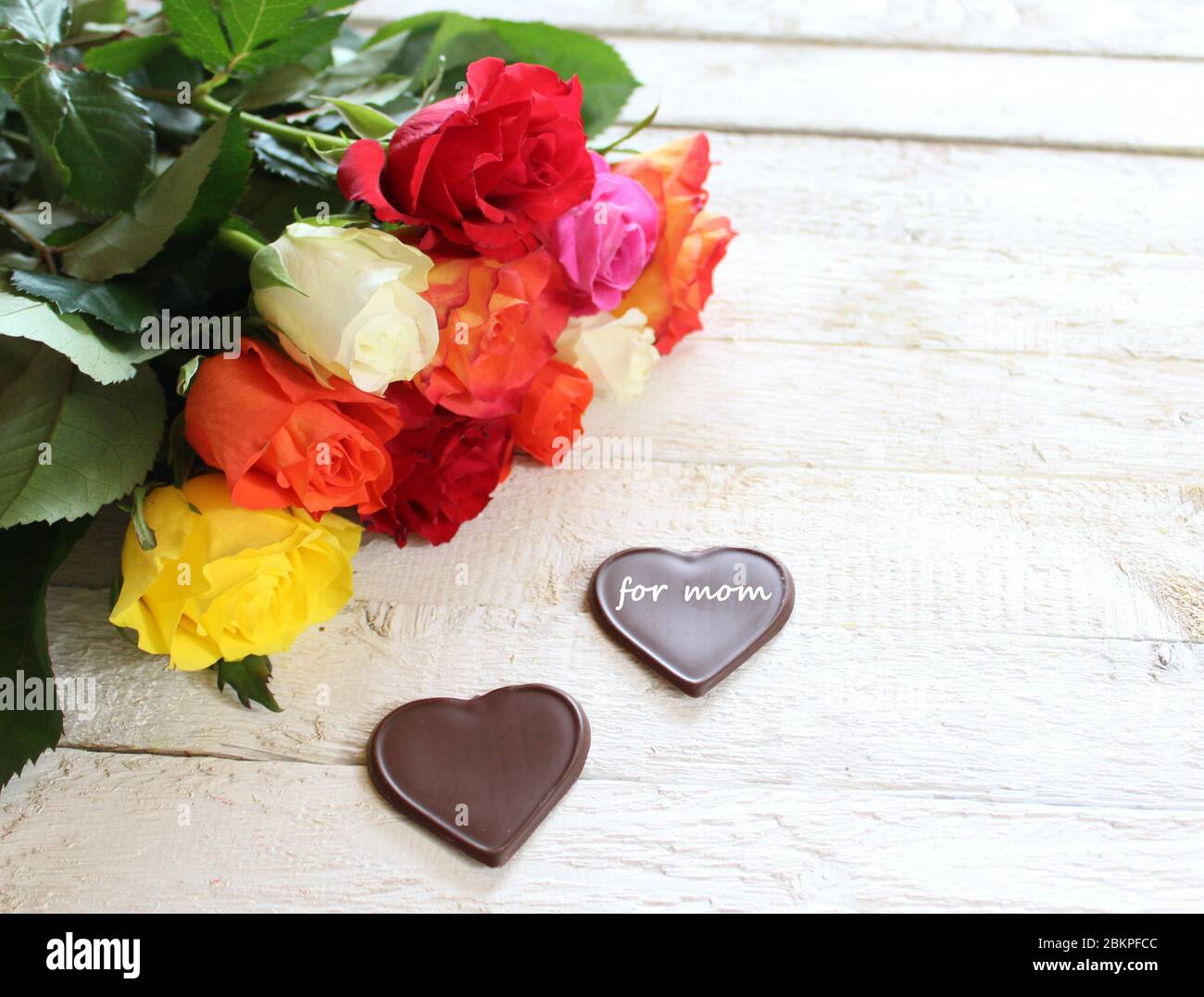 The picture shows colourful roses and chocolate hearts for mother`s day ...