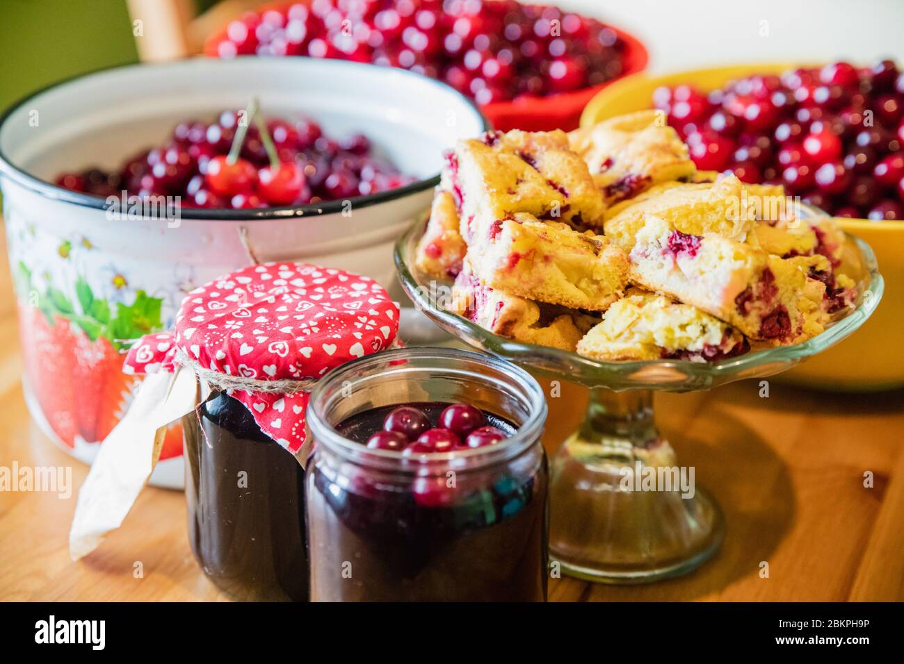 Jars of tasty summer cherry jam with baked cherry cake and raw cherries ...