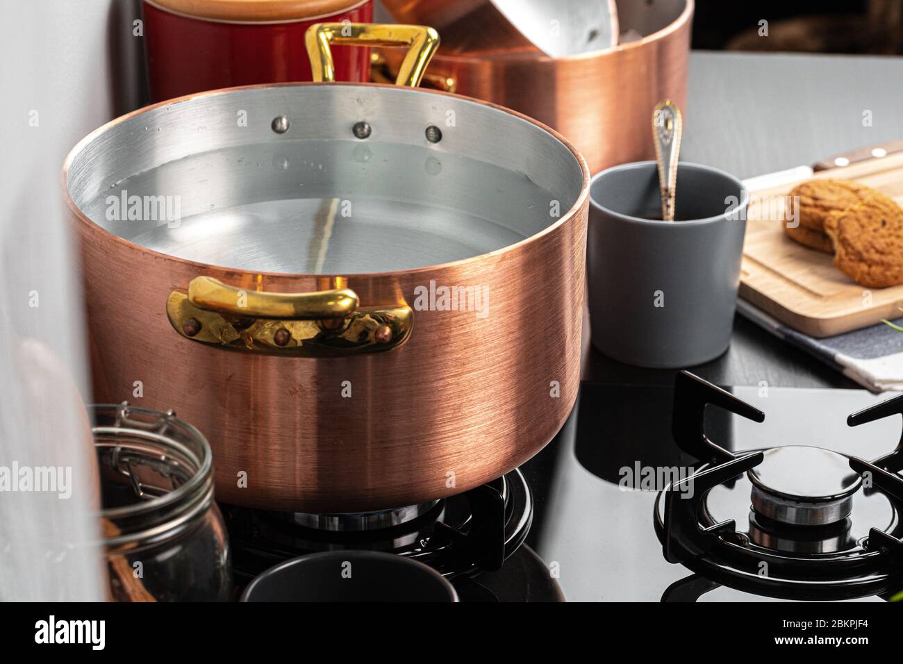 Copper pot with boiling water on a gas stove Stock Photo - Alamy