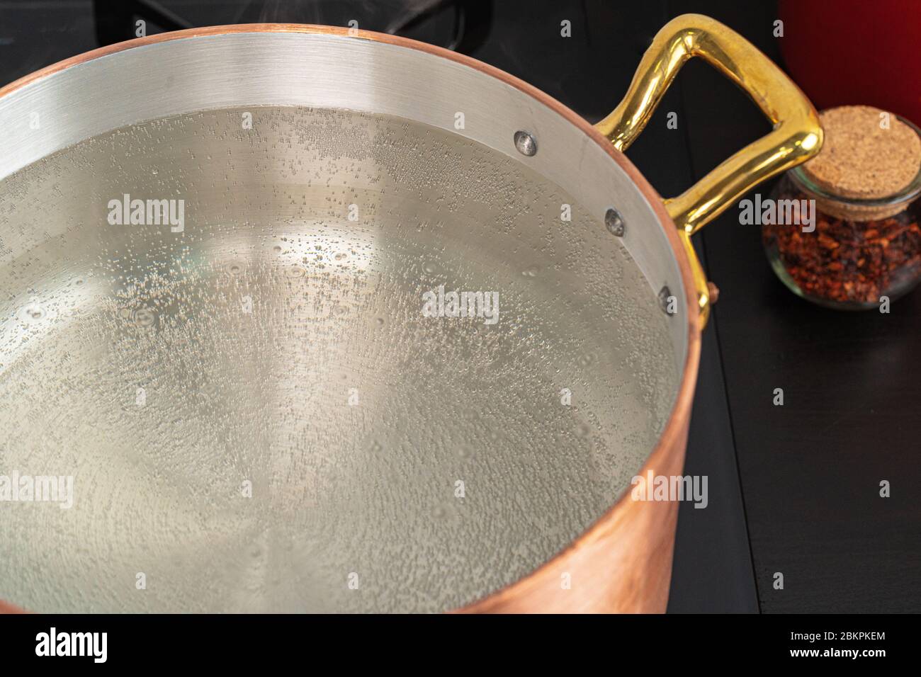 Copper pot with boiling water on a gas stove Stock Photo - Alamy