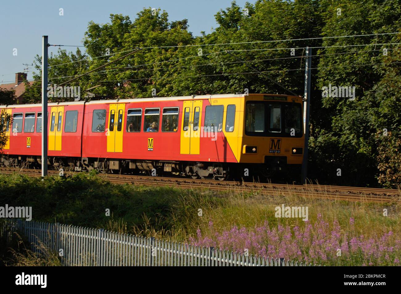 Newcastle Metro: train with red and yellow livery in coastal area of ...