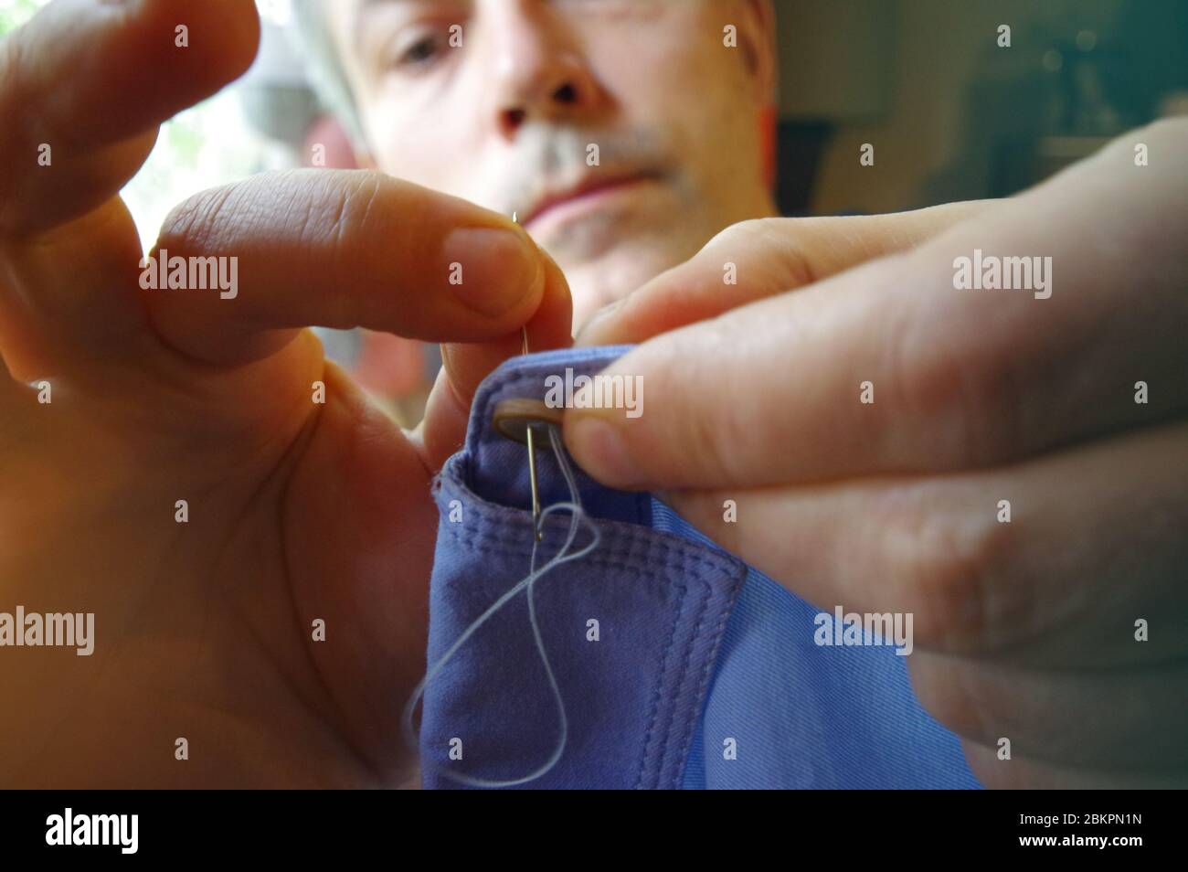 Tailor man with needle and thread in the hand. Handmade work. Manual ...