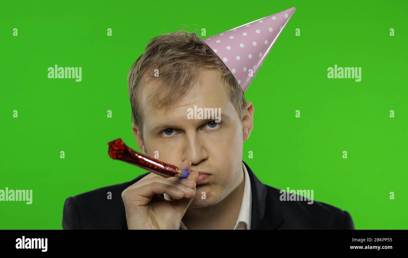Portrait of drunk unhappy young clerk man with hangover blowing a ...
