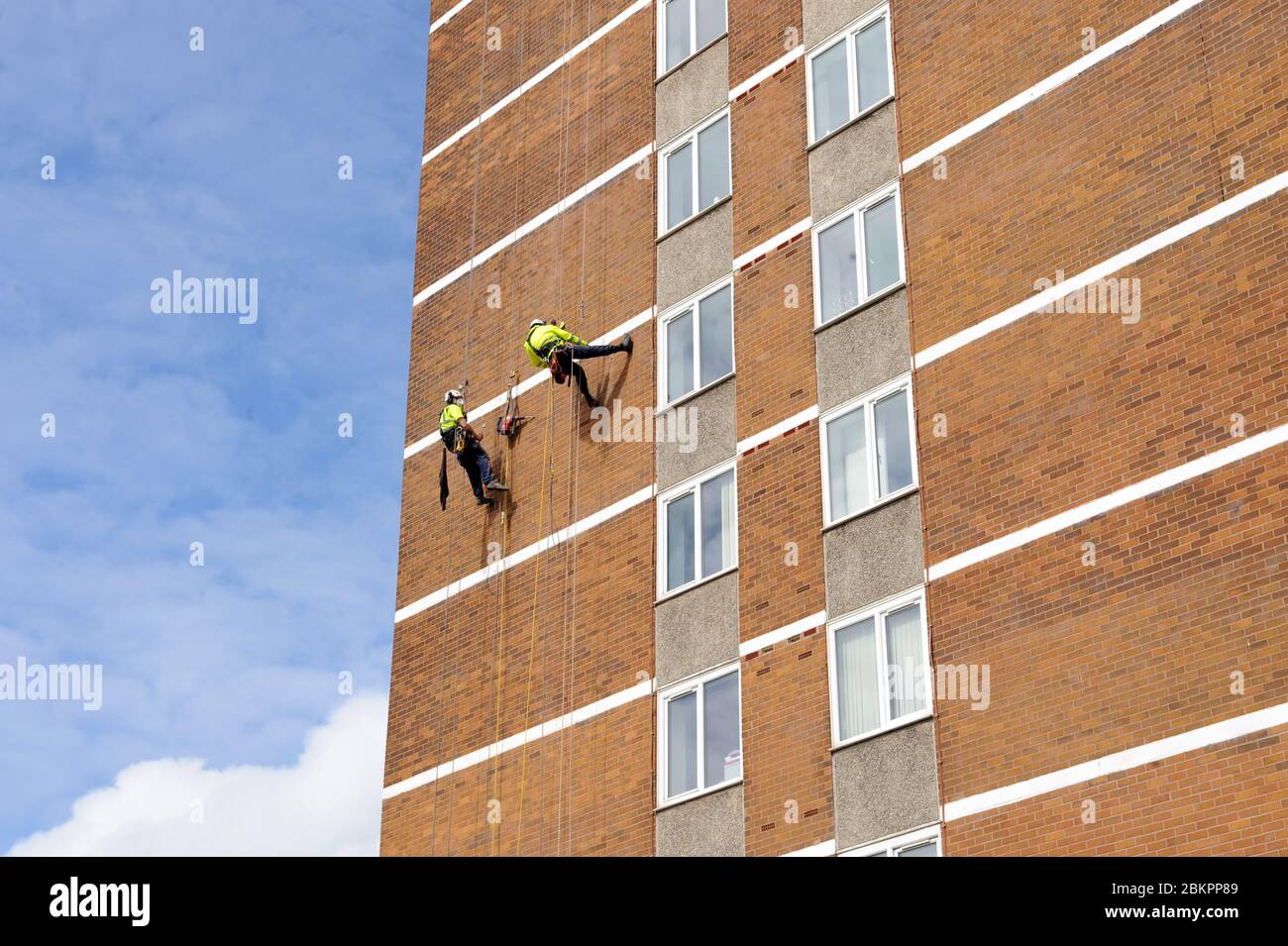 Men working at height on ropes. Industrial rope access workers on the ...