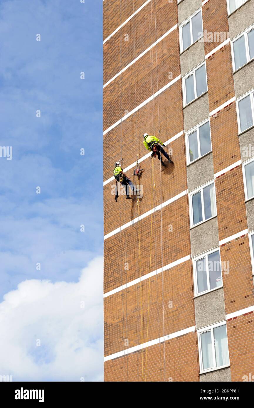 Men working at height on ropes. Industrial rope access workers on the ...