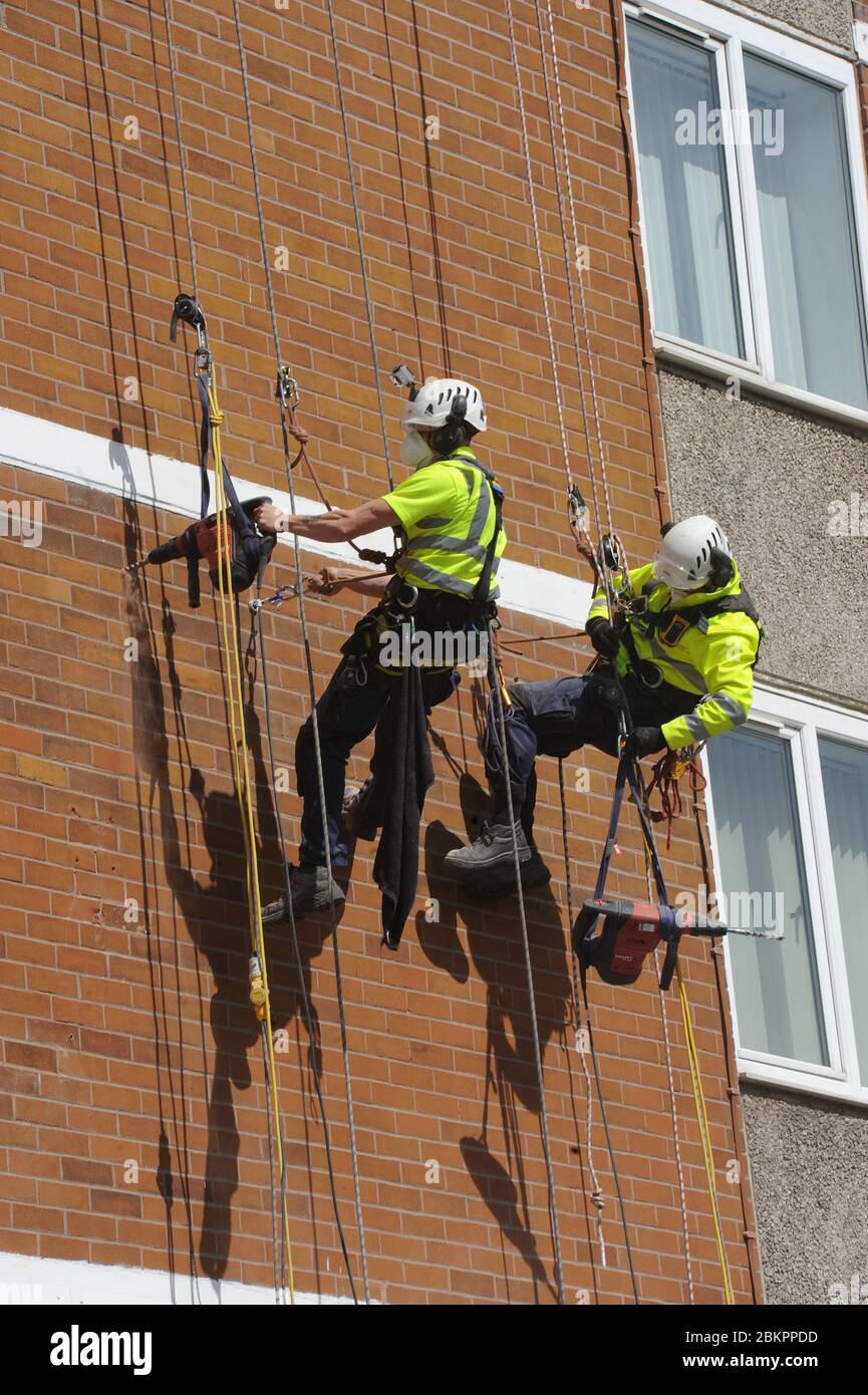 Men working at height on ropes. Industrial rope access workers on the ...