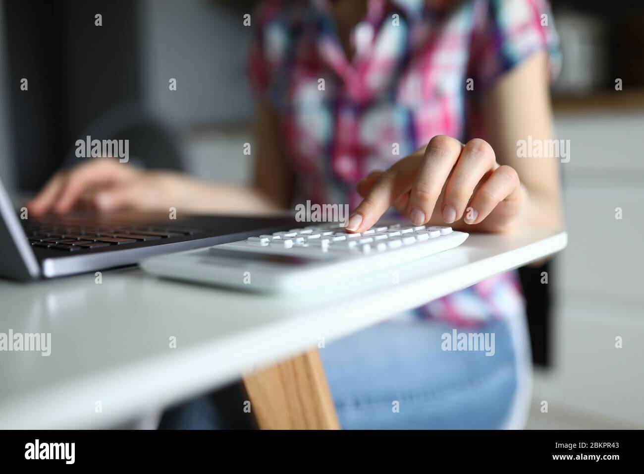 Female hand push button on white calculator closeup Stock Photo - Alamy