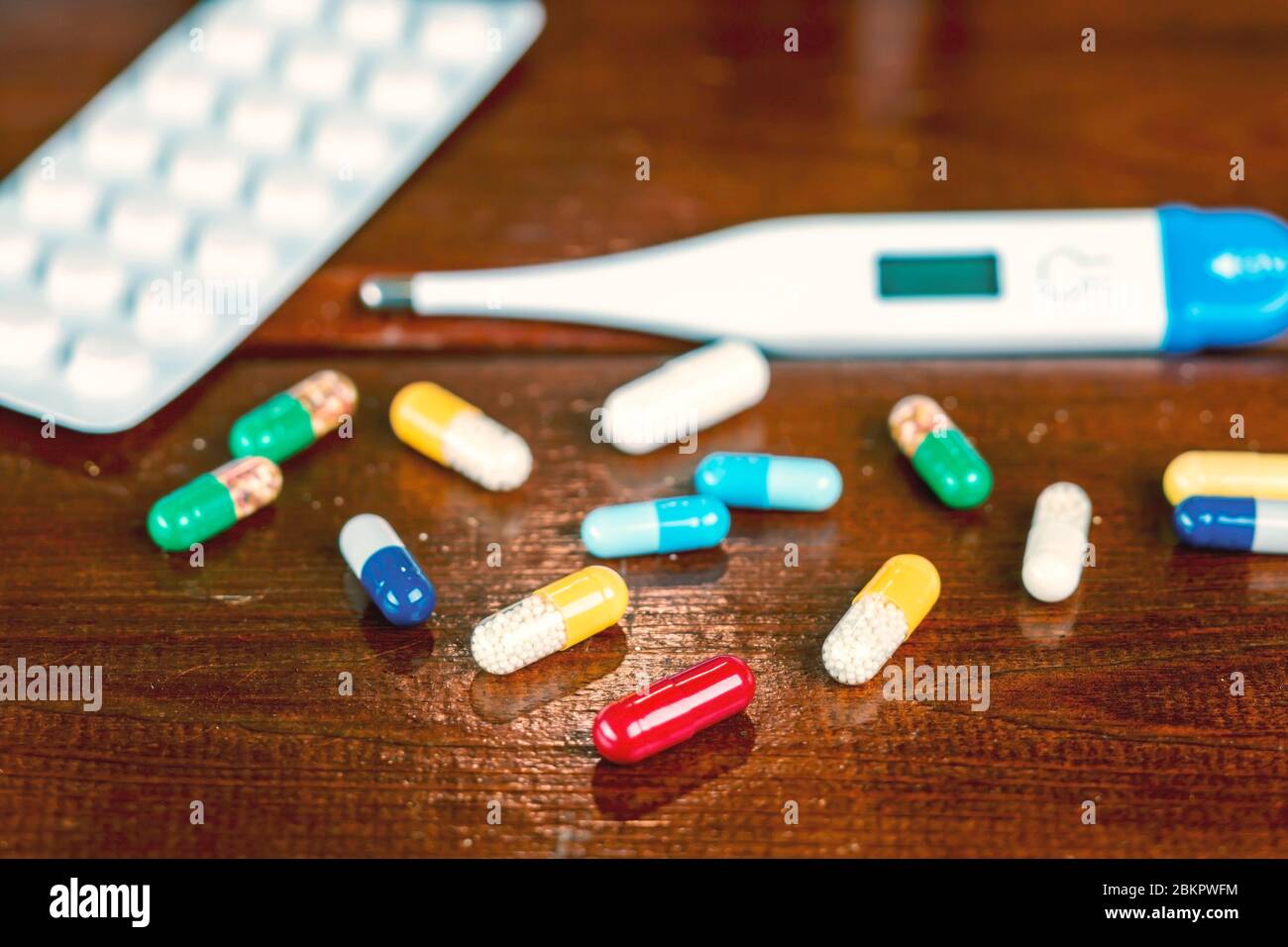 Colorful medications and digital thermometer Stock Photo - Alamy