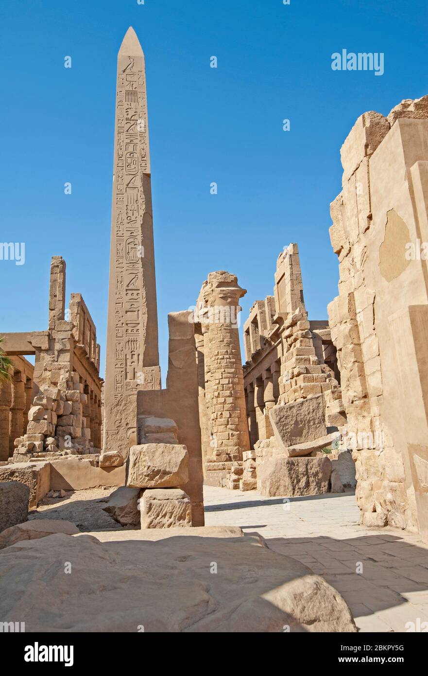 Large tall ancient egyptian obelisk at the temple of Karnak in Luxor with hieroglyphic carvings ...